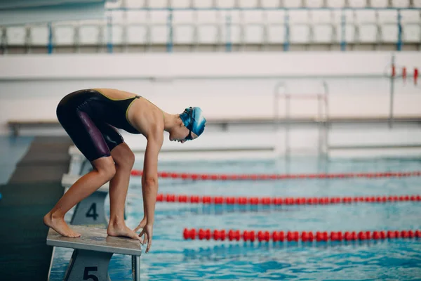 Young woman swimmer getting ready for competition and swim in swimming ...