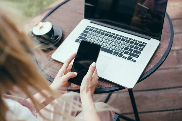Young pretty woman using phone in cafe, eat chocolate, drink cocktail ...