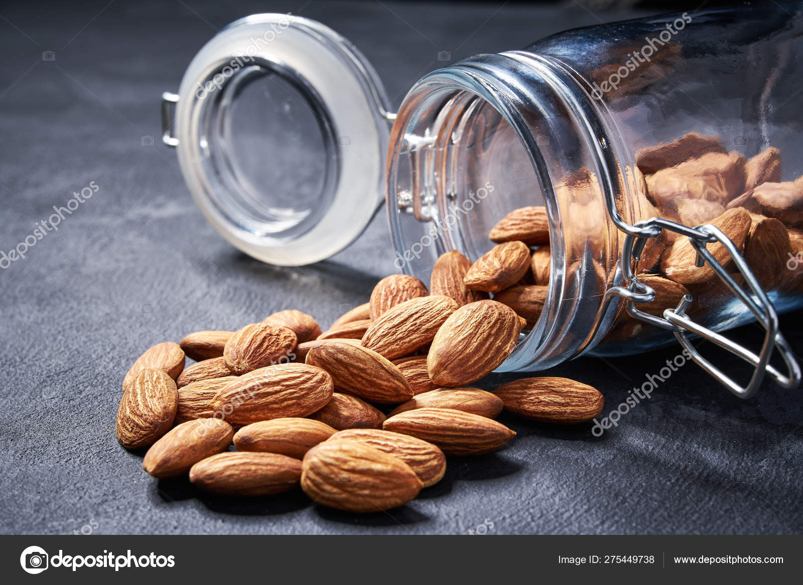 Almonds in an open glass jar on black table ,close-up , Stock Photo by ...