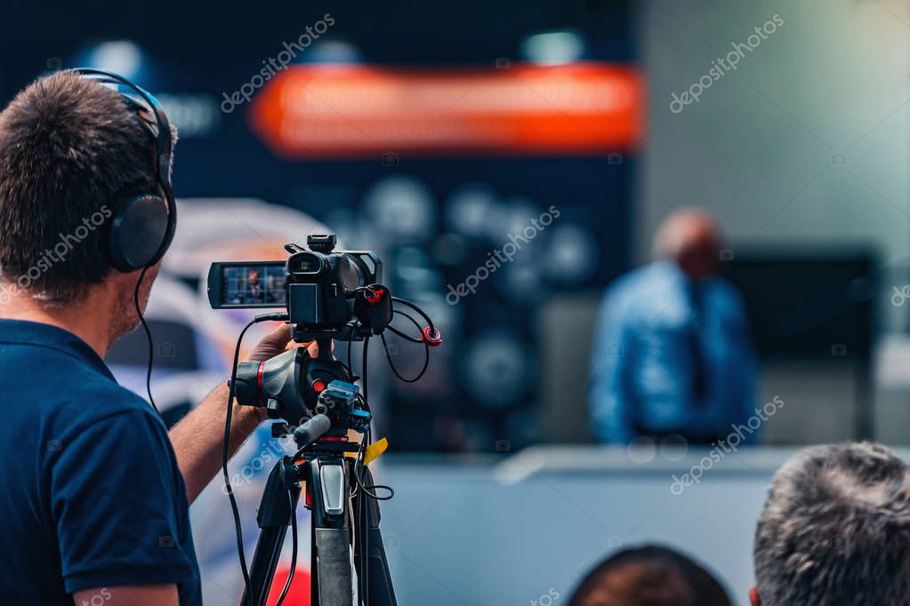 Camar grafo grabando altavoz masculino usando traje en conferencia de prensa de medios. Concepto ...