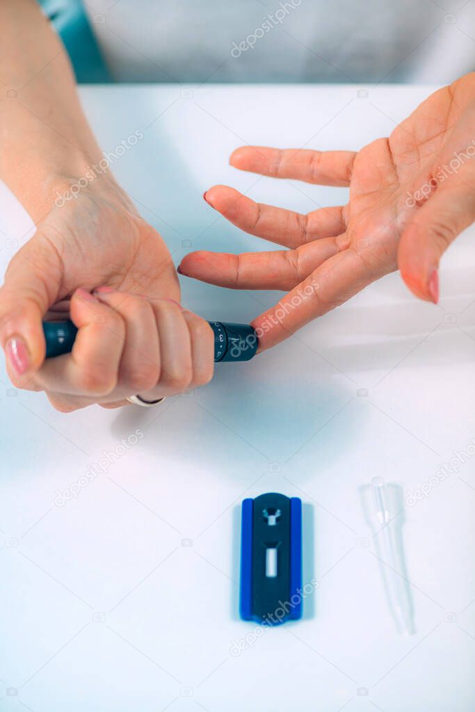 Mujer usando Lancet para extraer sangre para la prueba rápida del virus ...