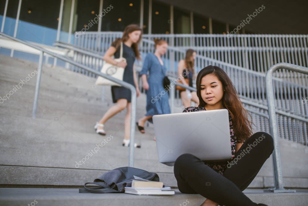 Joven estudiante universitaria asiática sentada en unas escaleras en el ...
