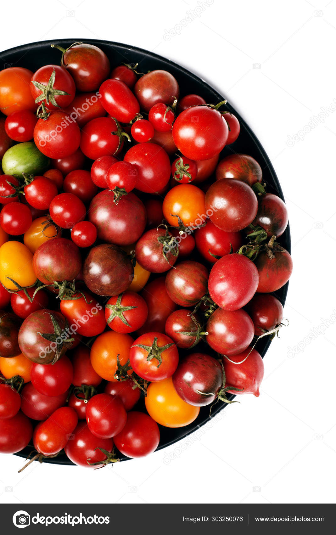 Multi-colored motley cherry tomatoes on a black plate, white bac Stock ...