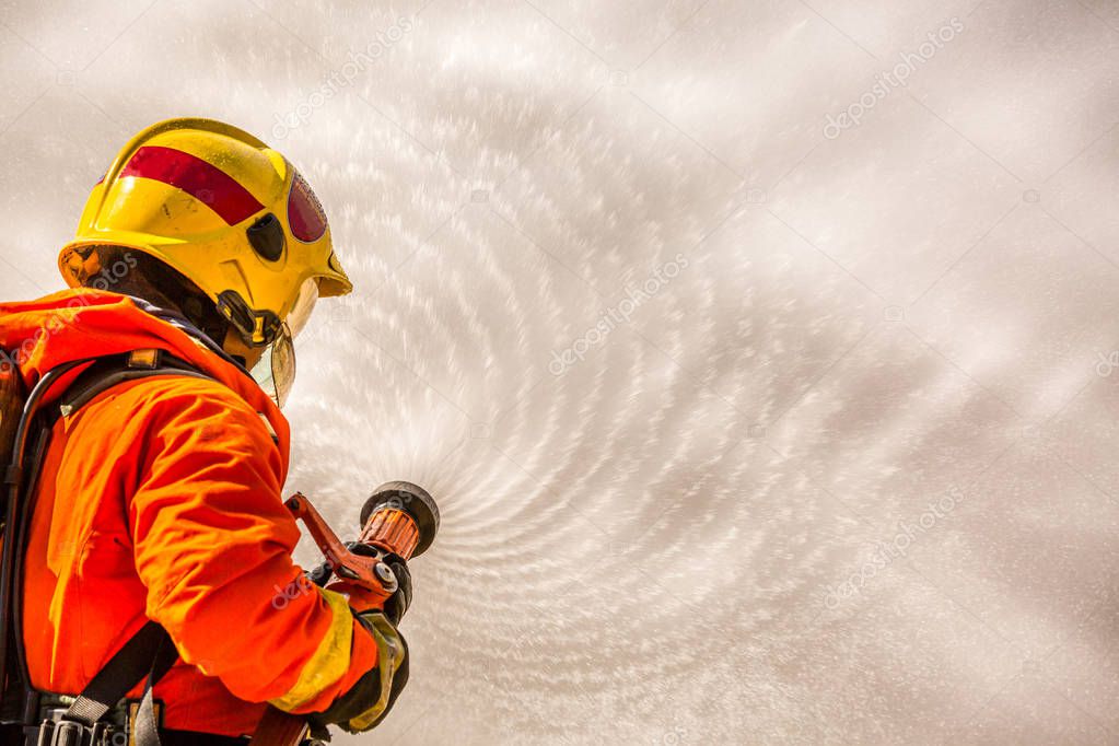 Bombero que utiliza extintor y agua de la manguera para la lucha contra ...