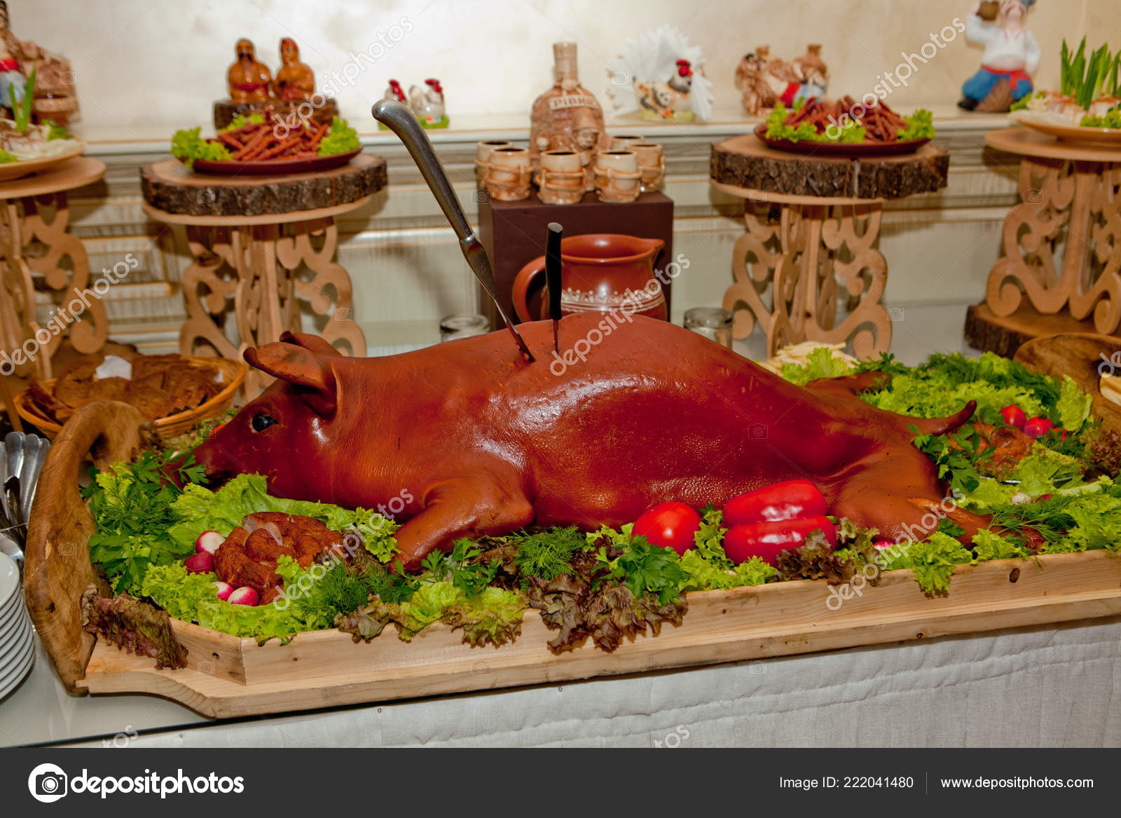 A young whole, baked pig, lying on a festive table decorated with herbs ...
