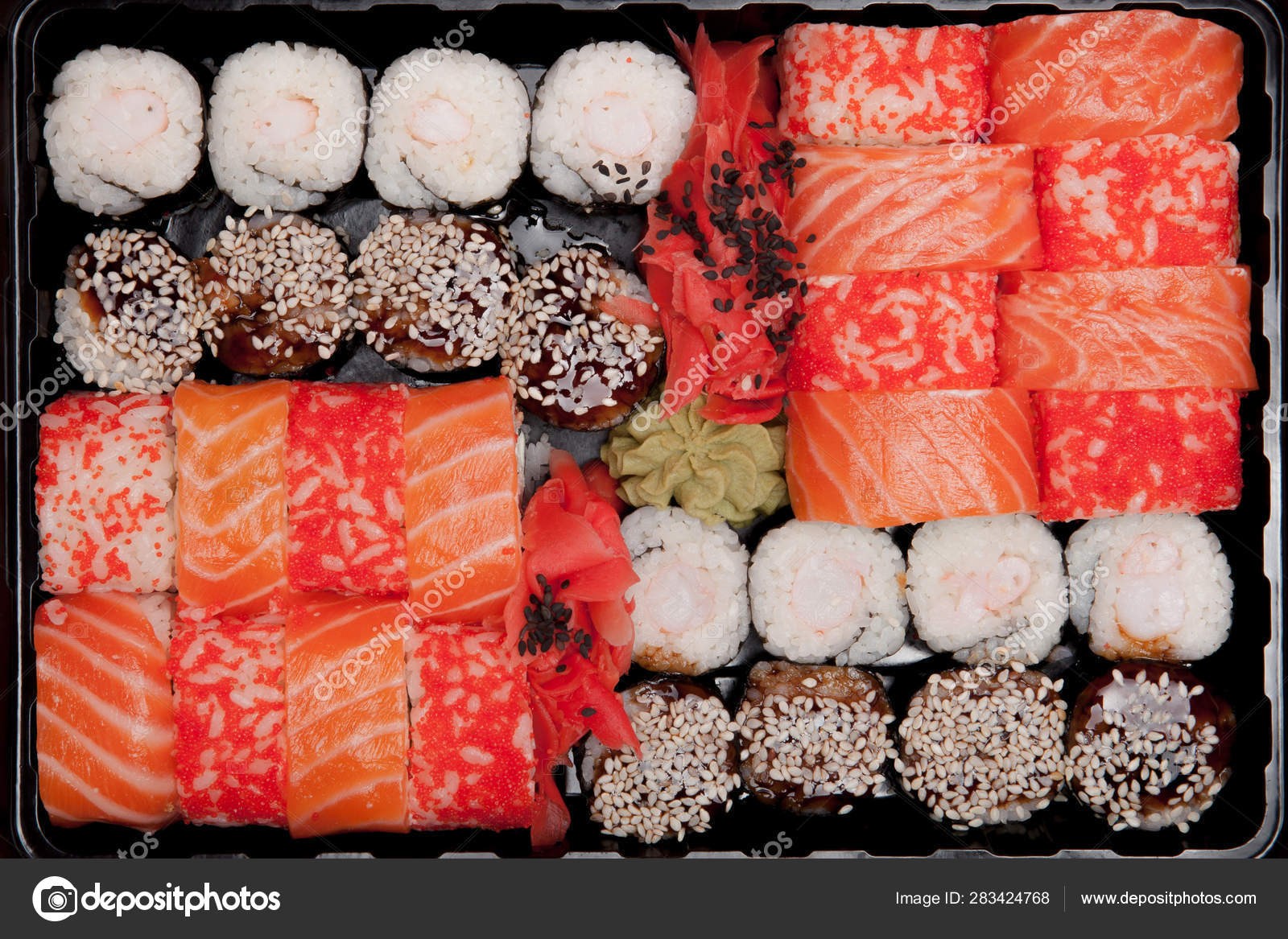 Big sushi set ib black plastic box on white background, top view close ...