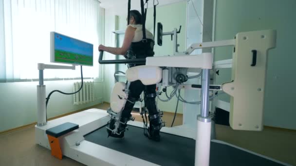 Prosthetic machine works at a clinic, helping a male patient to walk ...