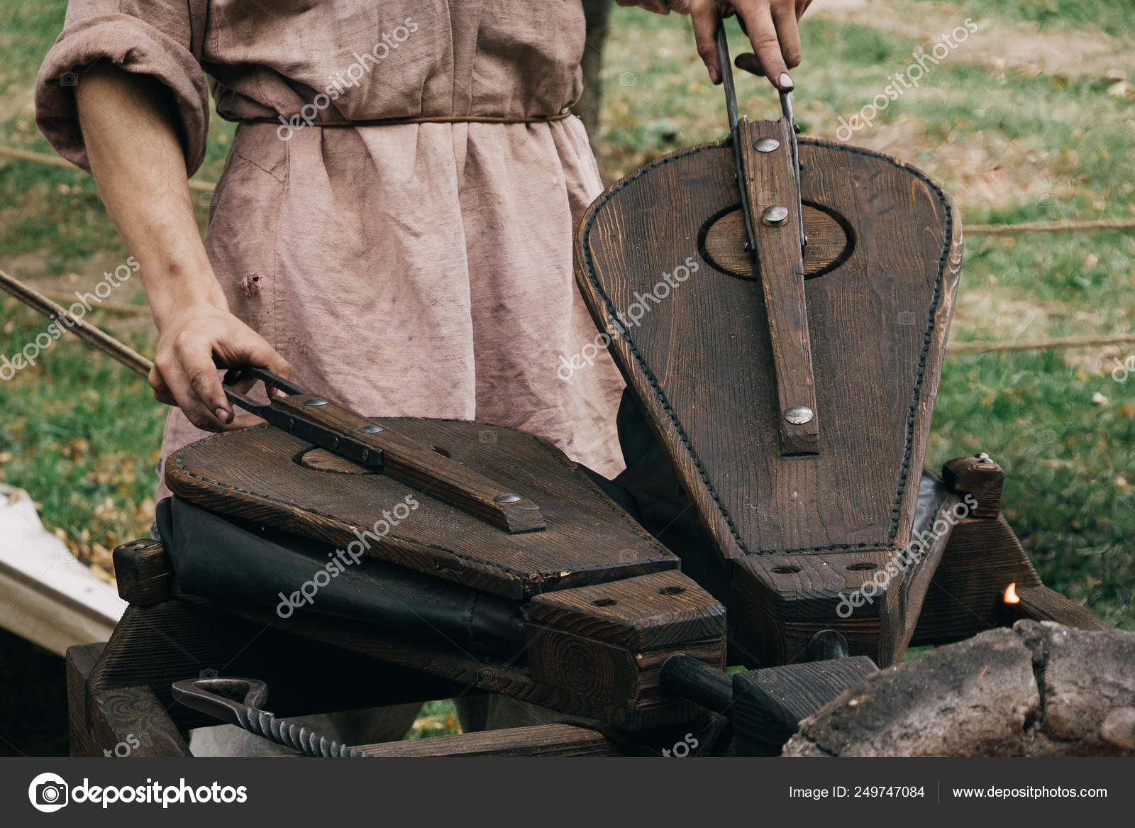 Blacksmith using pair of bellows to kindle fire in furnace Stock Photo ...