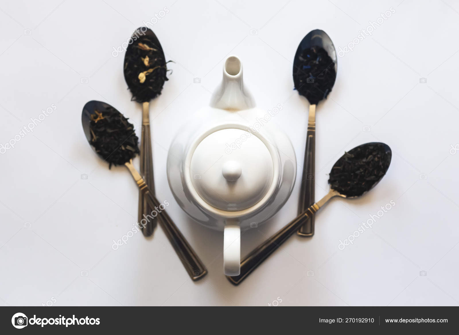 White ceramic tea pot and various dried teas on the white background ...