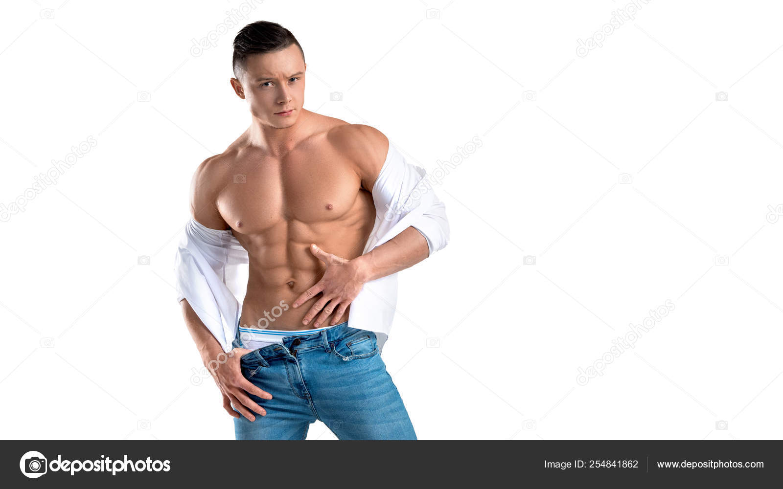 Man in blue jeans and white shirt touching his perfect abs isolated on ...