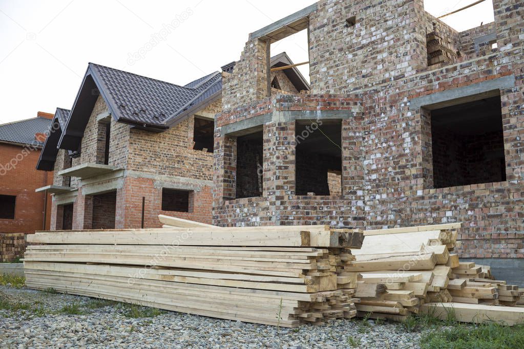 Futura casa de campo en construcción y pila de grava y pila de tablas ...