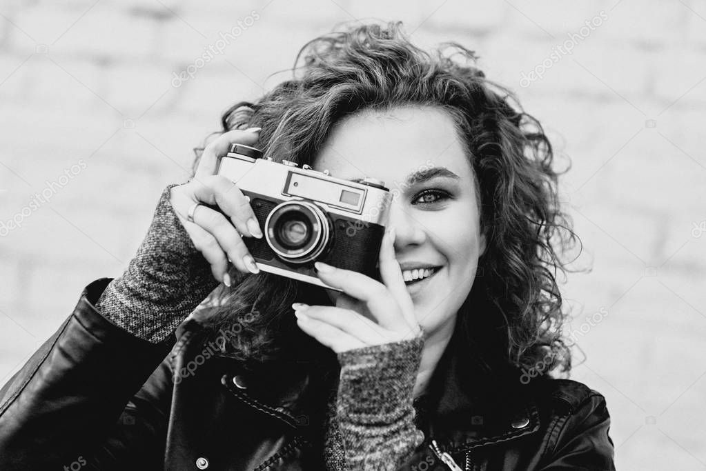 retrato monocromo de la joven hermosa mujer alegre con el pelo rizado rojo tomando fotos en la ...