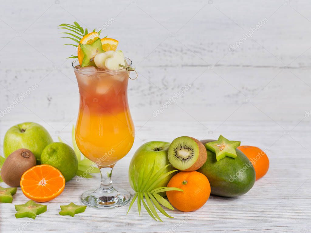 Cóctel de verano con varias frutas tropicales alrededor. Manzana, kiwi ...