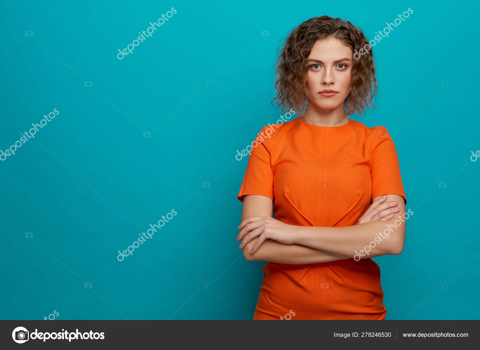 Serious model in orange dress with crossed hands. — Stock Photo ...