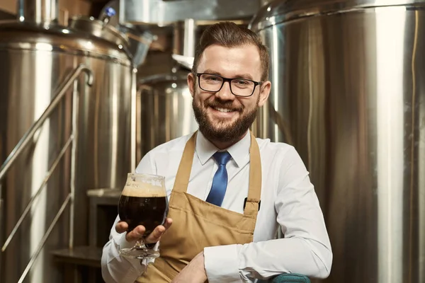 Front view of cheerful man keeping glass of root beer - Stock Image ...