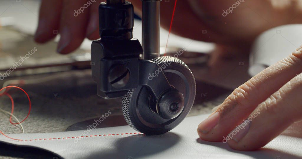 Primer plano de un zapatero cosiendo un cuero rojo utilizando una ...