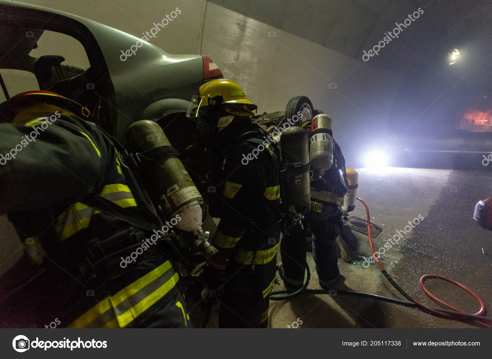 Car accident scene inside a tunnel, firefighters rescuing people from ...