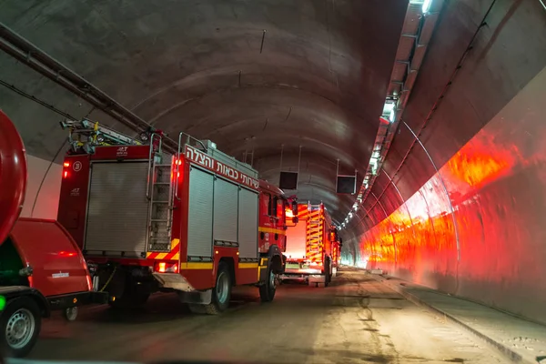 Fire trucks entering a large tunnel with red lights for rescue - Stock ...