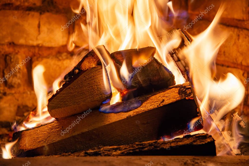 Leña quemándose en el fuego quema en la chimenea. El horno de ladrillo ...
