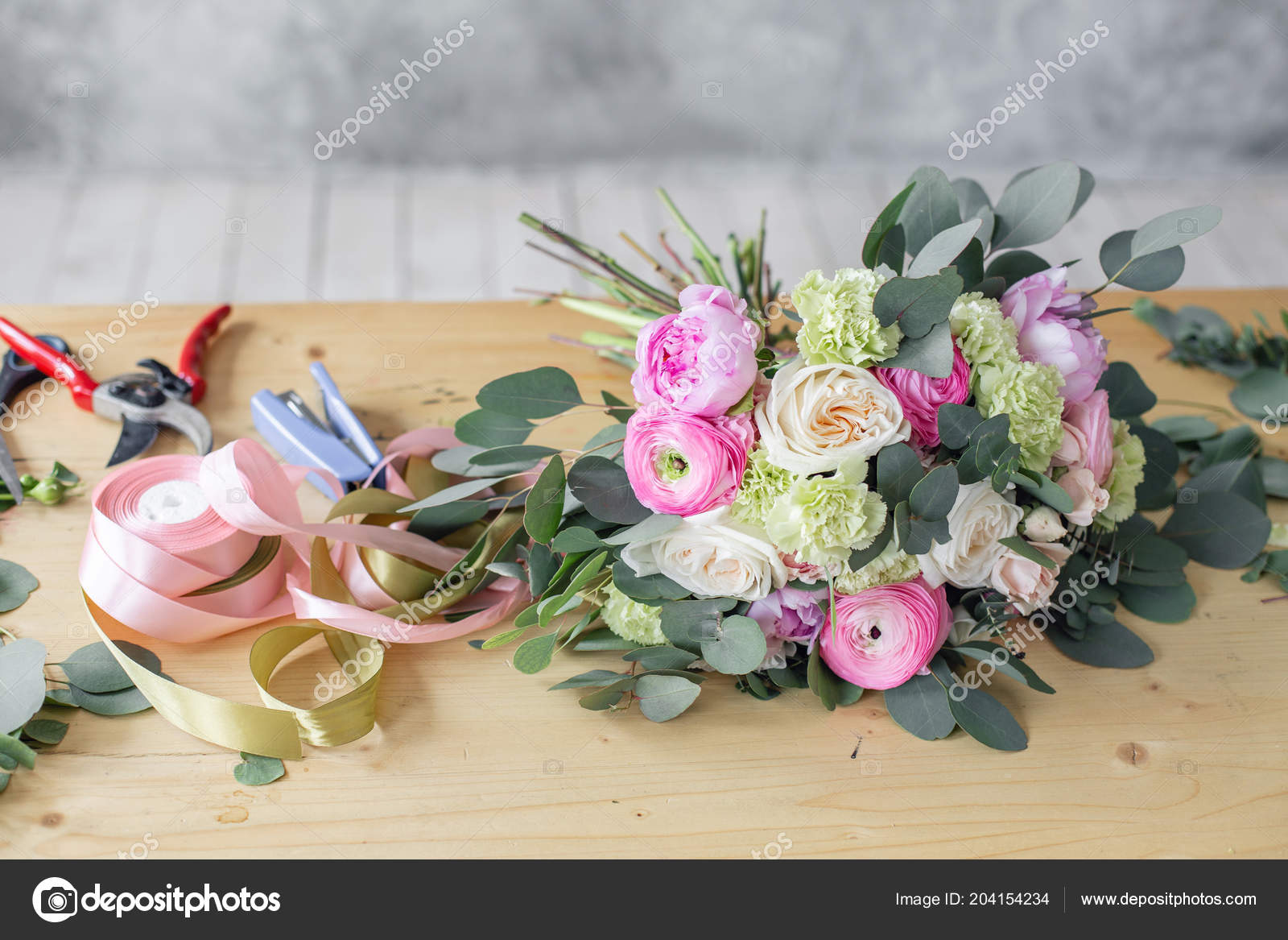 Working table in flower shop. Girl assistant or owner in floral design ...