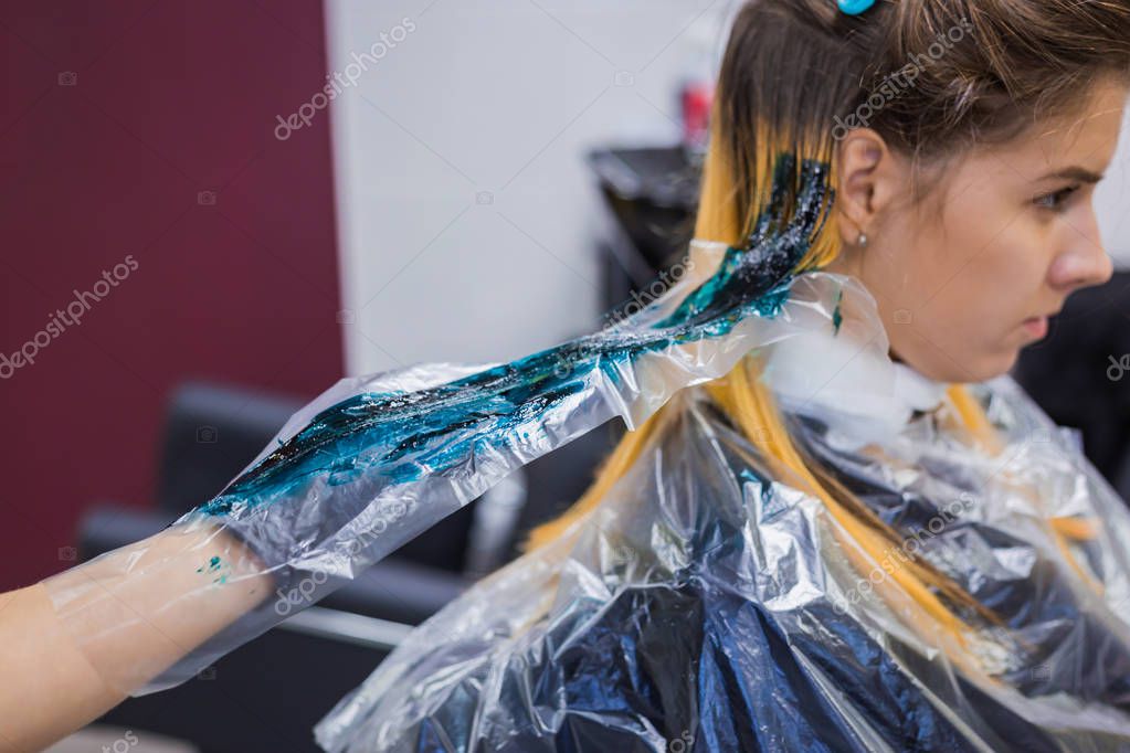 Peluquer a profesional para colorear el cabello de la mujer cliente en el estudio 2024