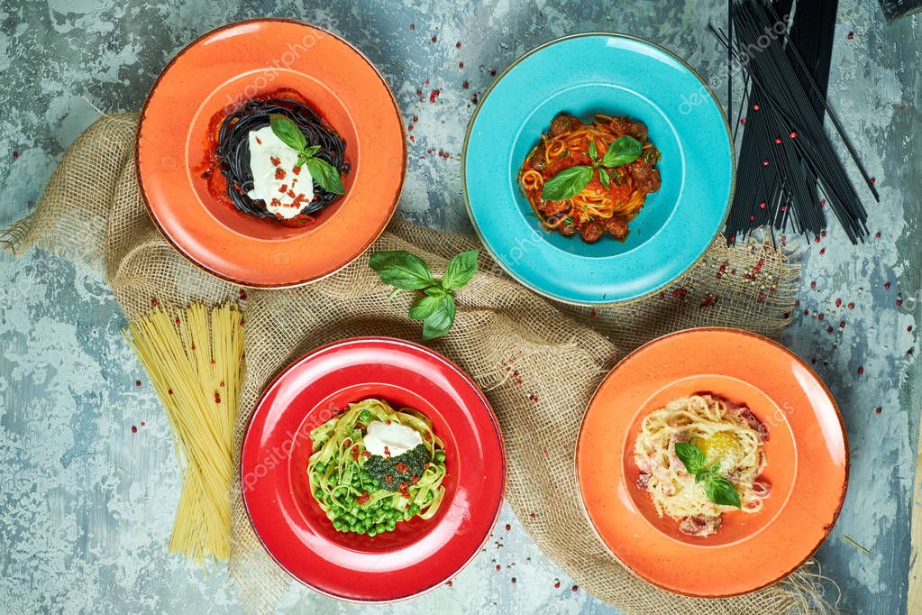 Platos multicolores con pasta. Fondo gris claro texturizado. Hermosa ...
