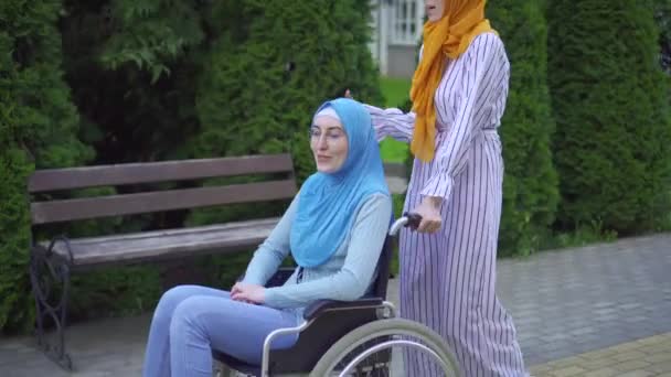 Young muslim disabled in a traditional scarf in a wheelchair ...