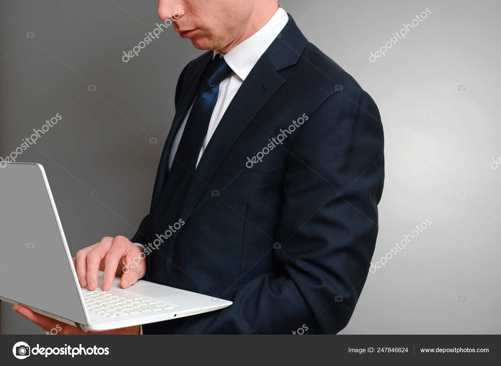 Man in a suit typing whilst holding a laptop computer — Stock Photo ...