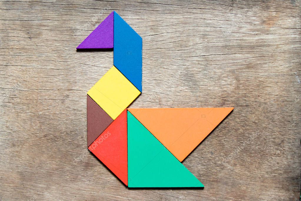 Tangrama de color en forma de cisne sobre fondo de madera 2024