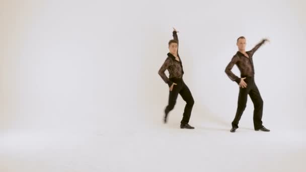 Two men, ballet dancers, dancing in the studio on a white background. ⬇ ...
