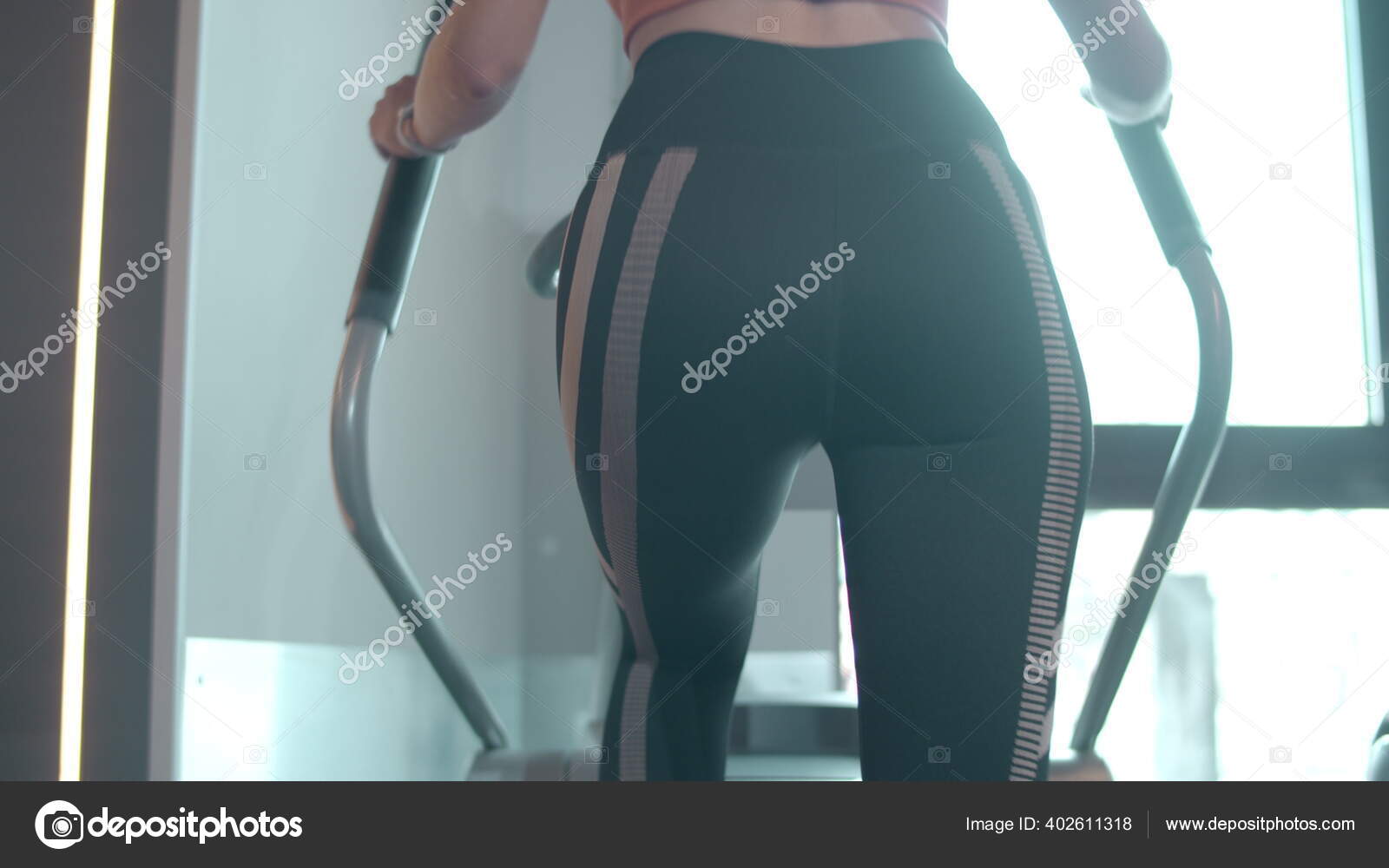 Fit girl using elliptical trainer in sport club. Sport woman training ...