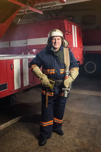 Fireman (firefighter) in action standing near a firetruck. Emergency ...