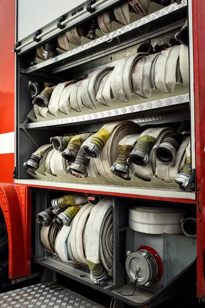 Compartment of rolled up fire hoses on a fireengine. Emergency safety ...