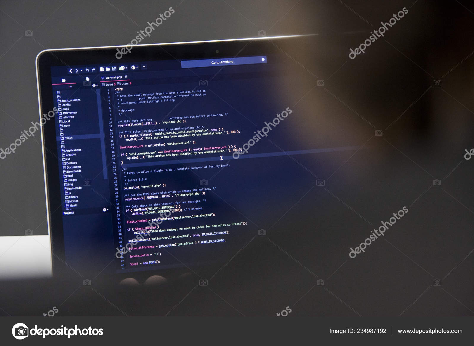 Male programmer working on laptop computer at white desk in office ...