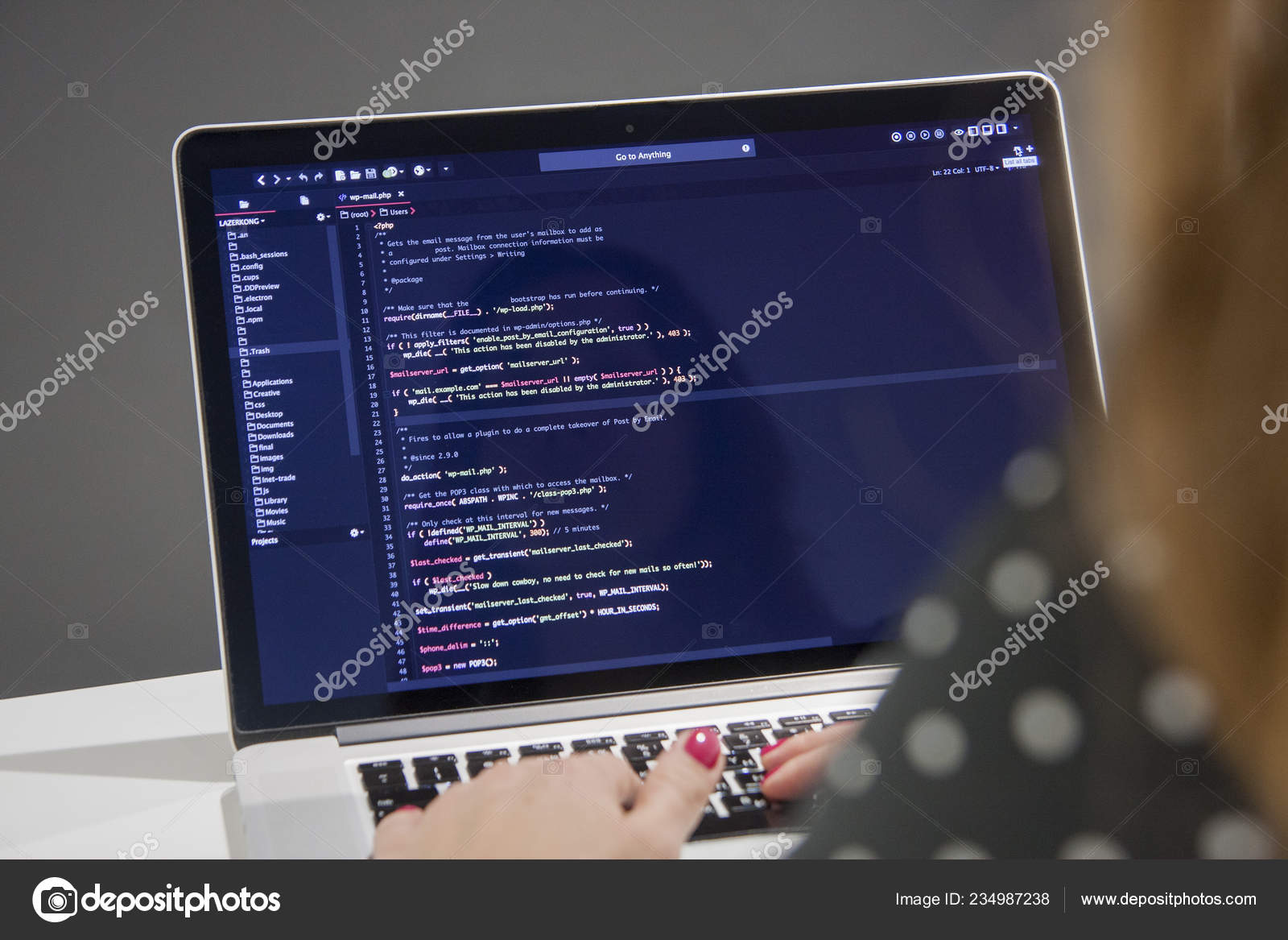 Woman programmer with cup of coffee working on laptop computer in ...