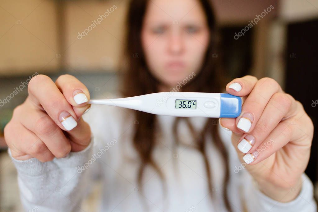 Thermometer for measuring temperature and in the hands of a person with ...