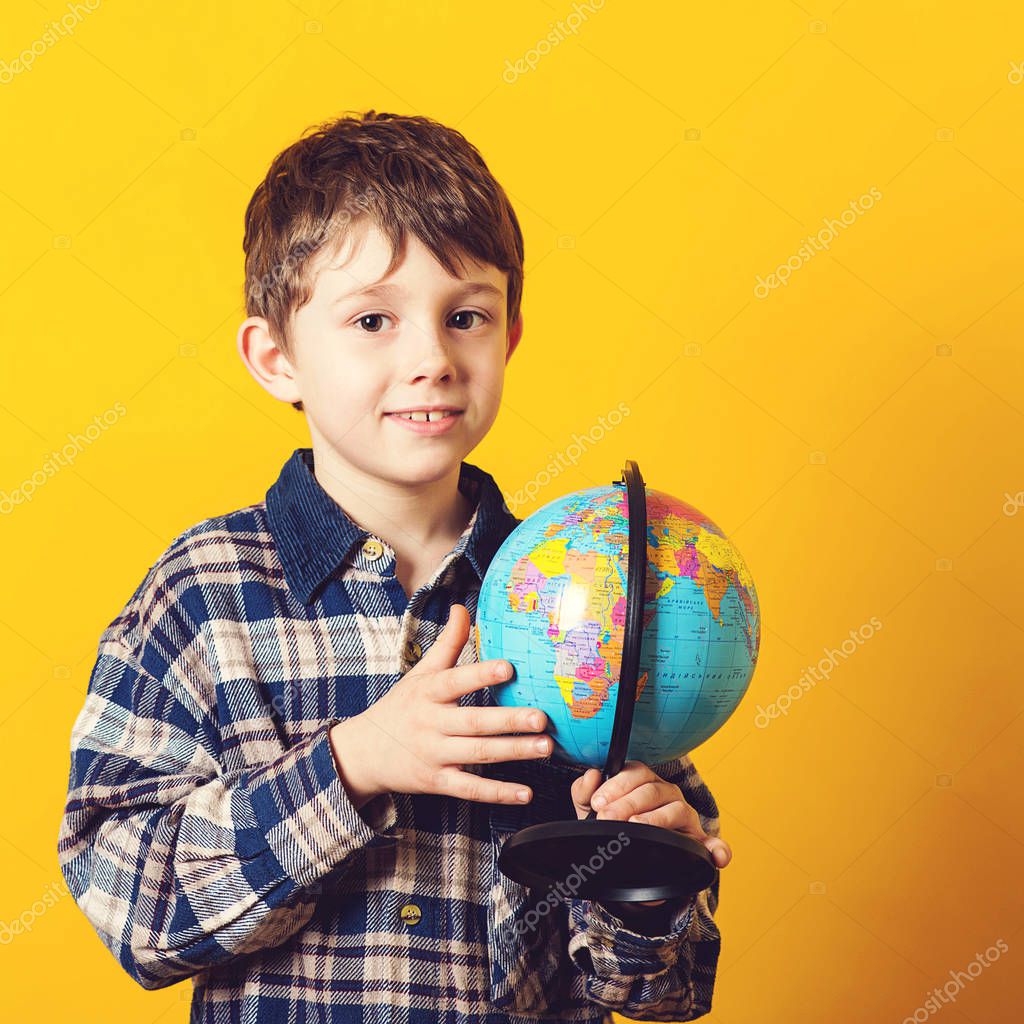 Un chico curioso sosteniendo el mapa de la Tierra. Pequeño viajero ...