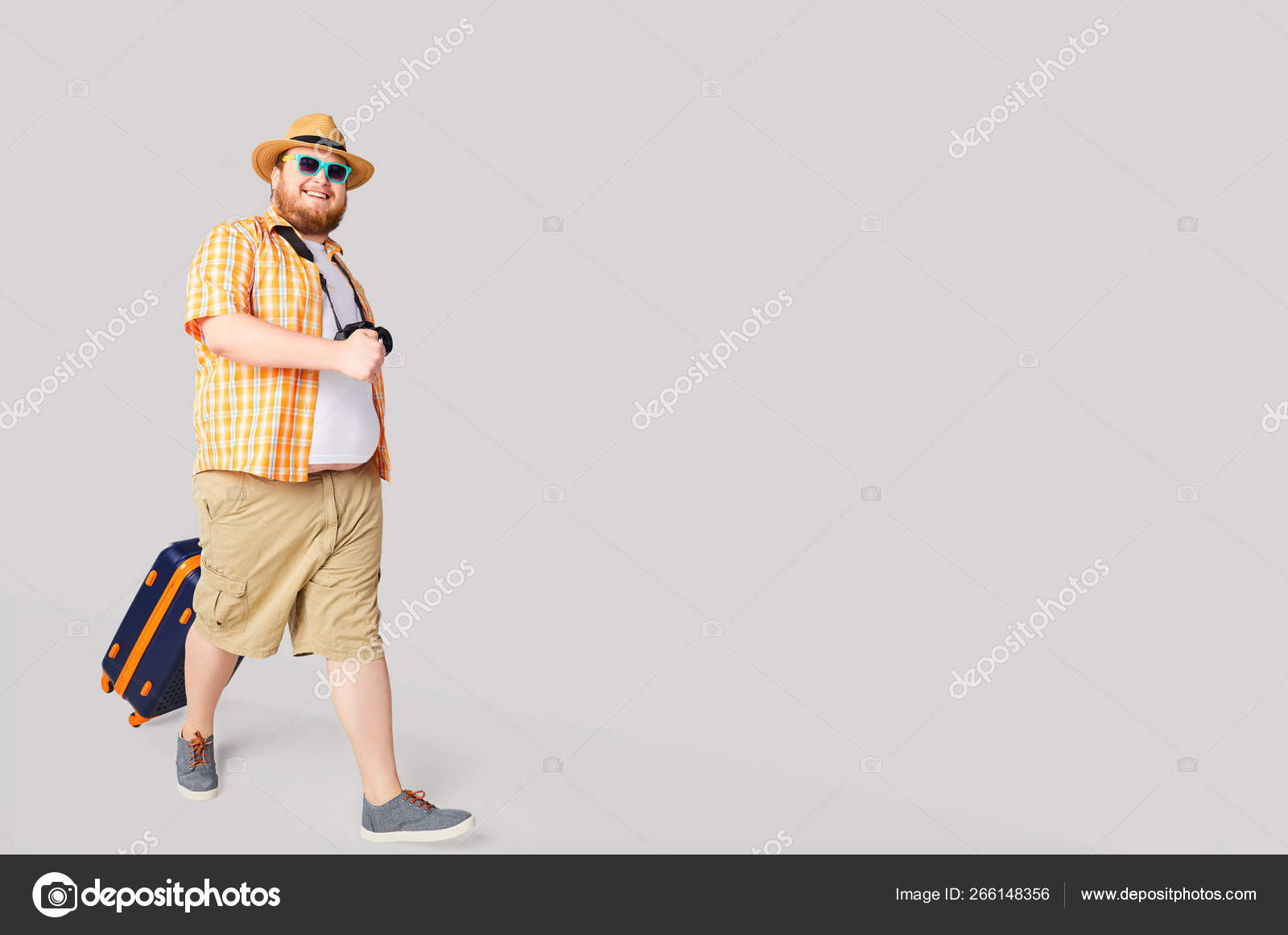 Fat funny man with a suitcase smiling on a gray background. Stock Photo ...