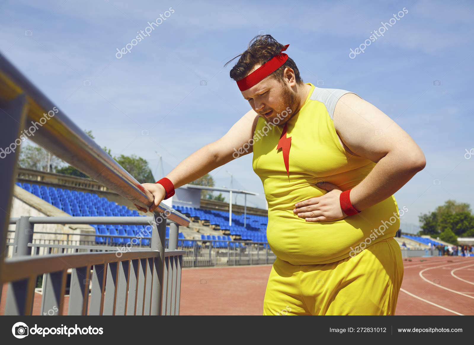 Abdominal pain in a fat man in training at the stadium. Stock Photo by ...
