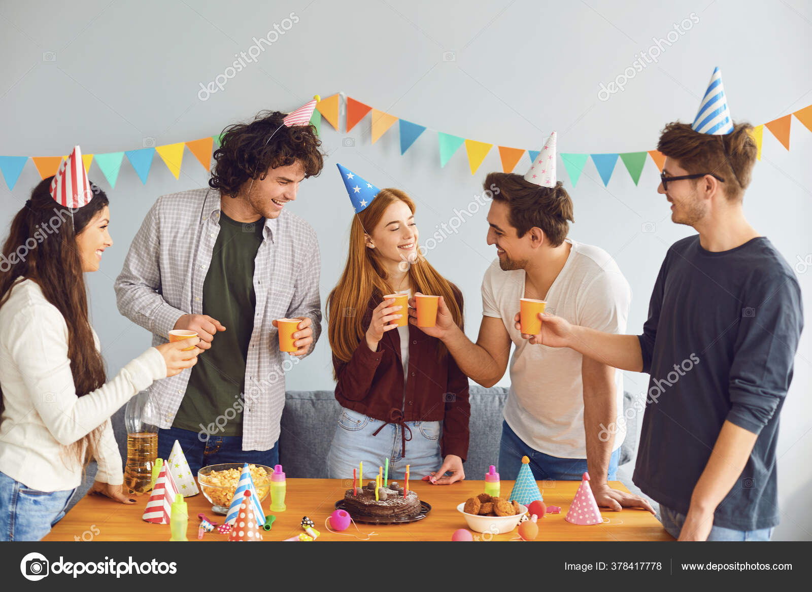 Feliz fiesta de cumpleaños. Un grupo de amigos con un pastel desea a la ...