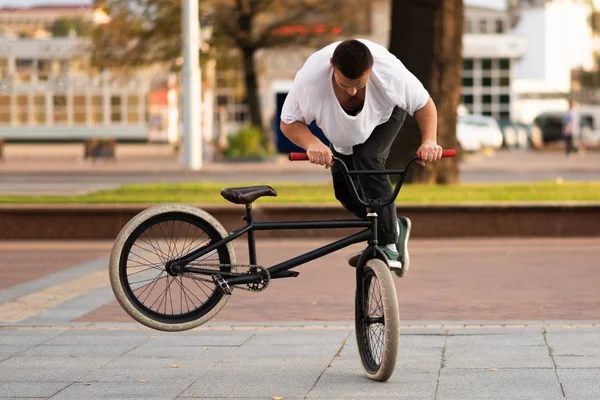 The guy on the stunt bike, spins the bike on the front wheel, around ...