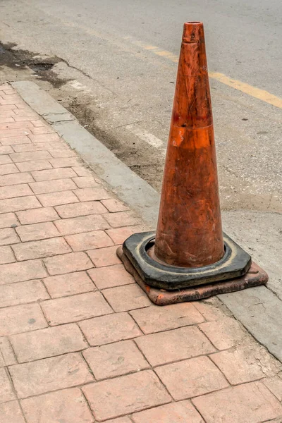 Plastic orange cone on concrete sidewalk - Stock Image - Everypixel