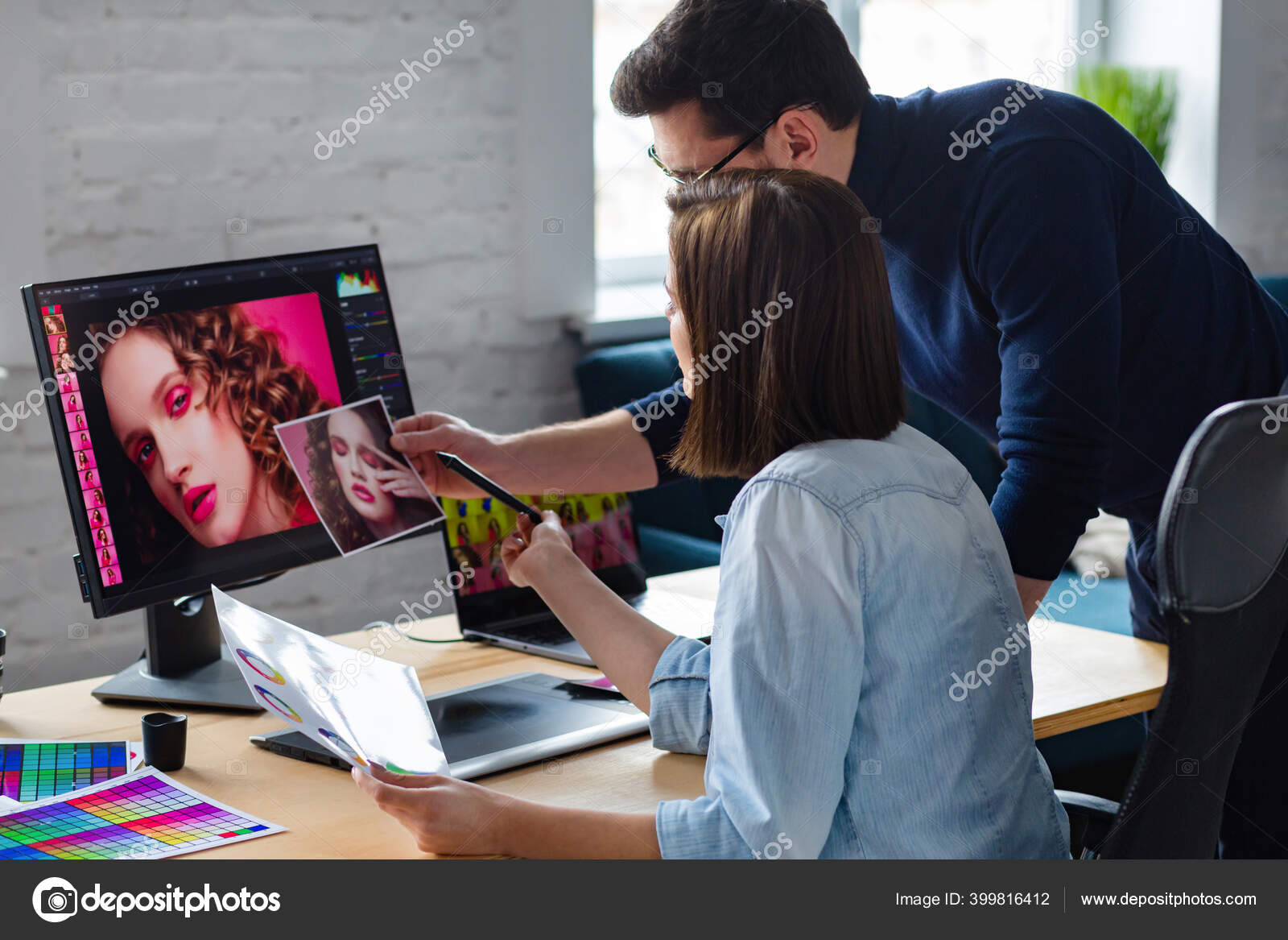 Photographer and graphic designer working in office with laptop ...