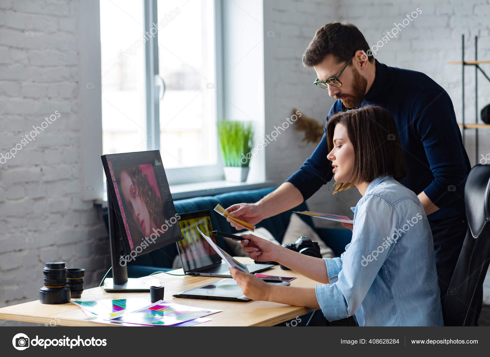 Photographer and graphic designer working in office with laptop ...