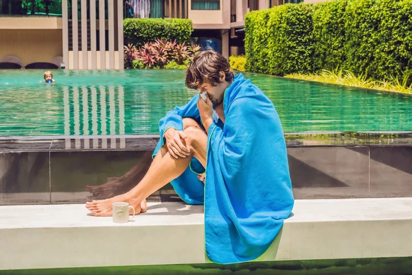 Sick man traveler. The man caught a cold on vacation, sits sad at the ...