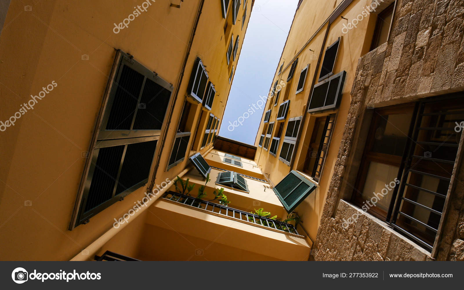 A view of a roofs from the narrow alley - yellow buildings and balcony ...