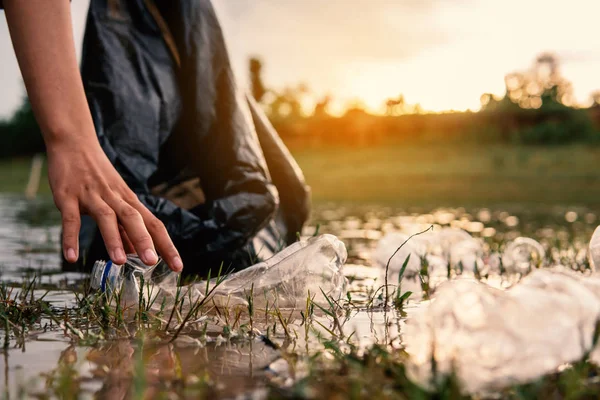 Human picking up a bottle plastic in the river , protect environment ...