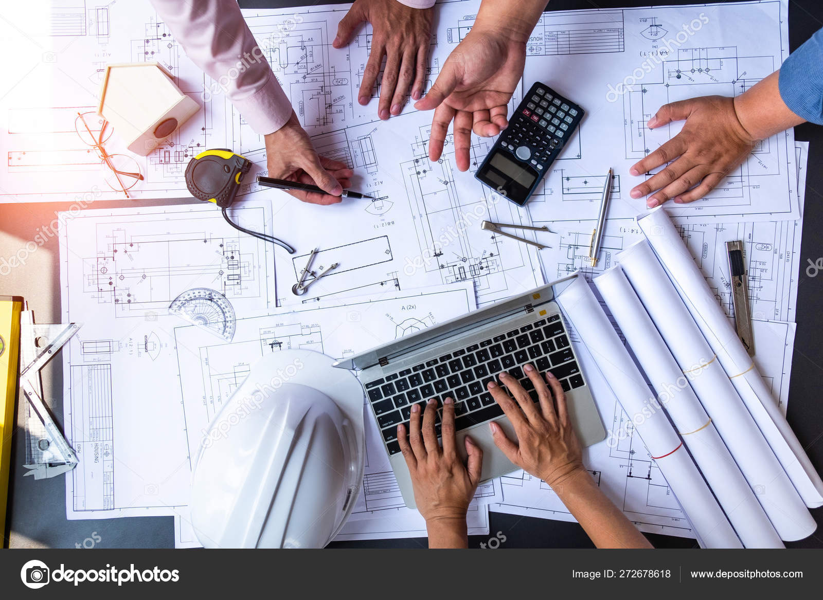 Engineers pointing to building on blueprint and using laptop to — Stock ...