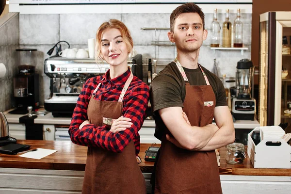 two baristas standing back to back at workplace in coffee shop - Stock ...