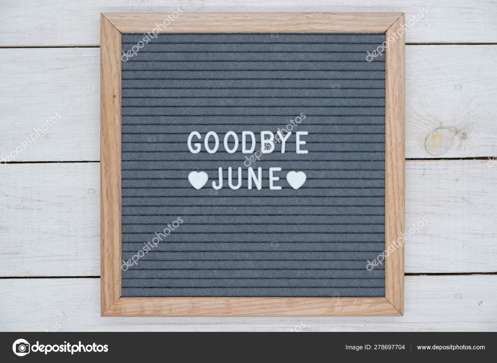 Text in English goodbye June and a heart sign on a gray felt Board in a ...